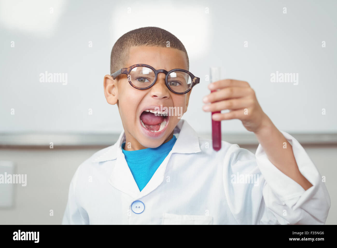 Surprised pupil with lab coat looking at test tube Stock Photo - Alamy