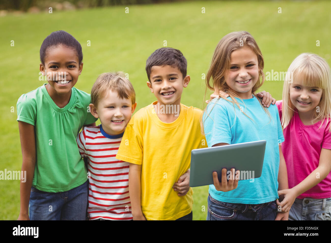 Smiling classmates holding tablet Stock Photo - Alamy