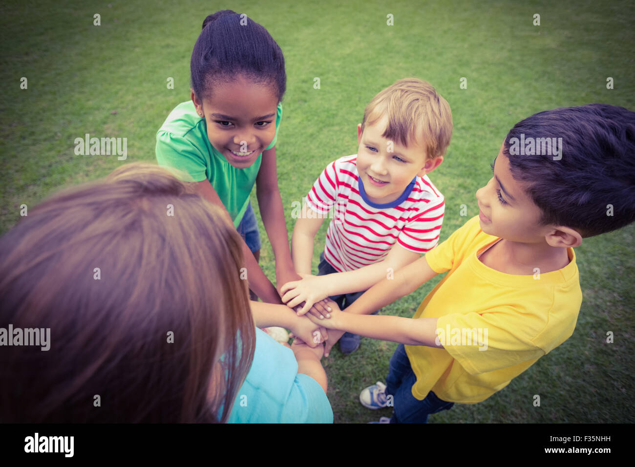 Smiling classmates putting hands together Stock Photo - Alamy