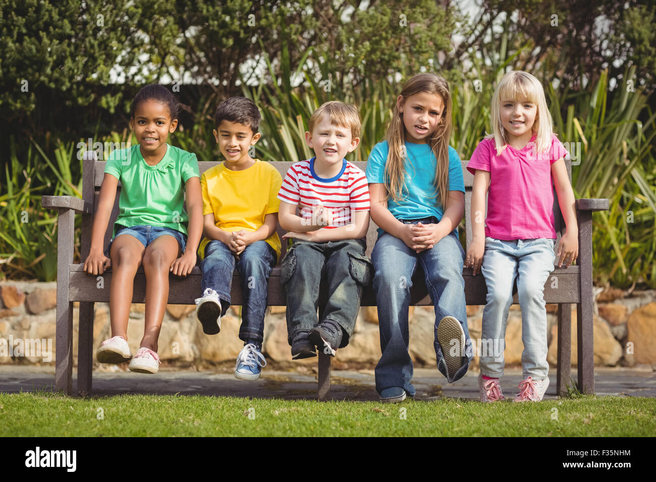 Smiling classmates sitting on bench Stock Photo - Alamy