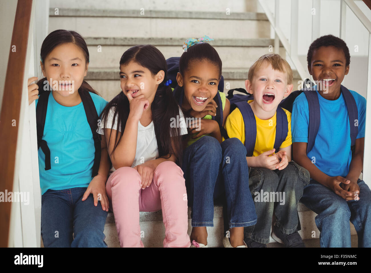 Happy pupils laughing and sitting on stairs Stock Photo - Alamy