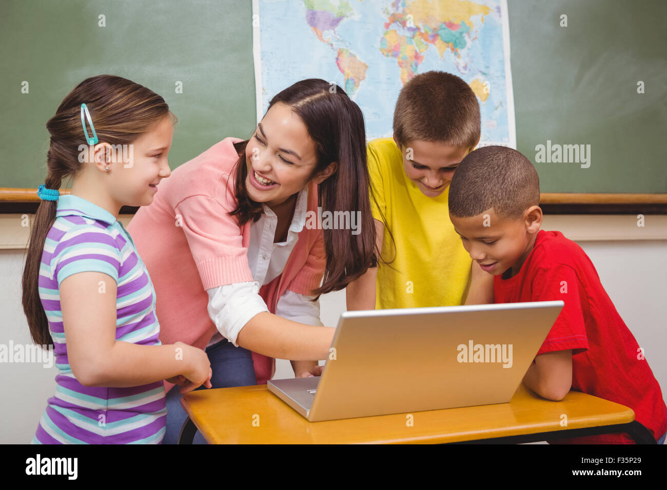 Students and teacher using a laptop Stock Photo - Alamy