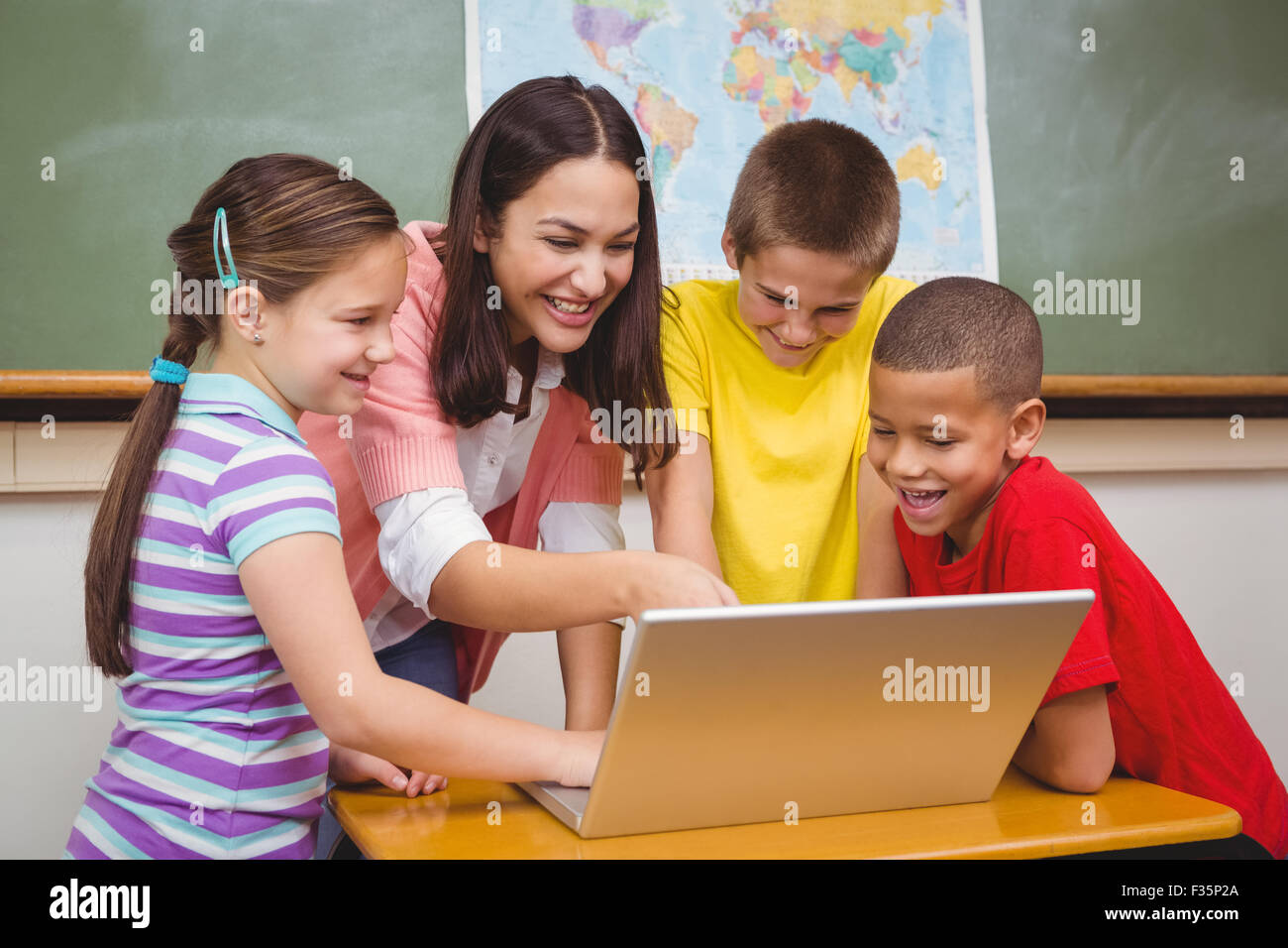 Students and teacher using a laptop Stock Photo - Alamy
