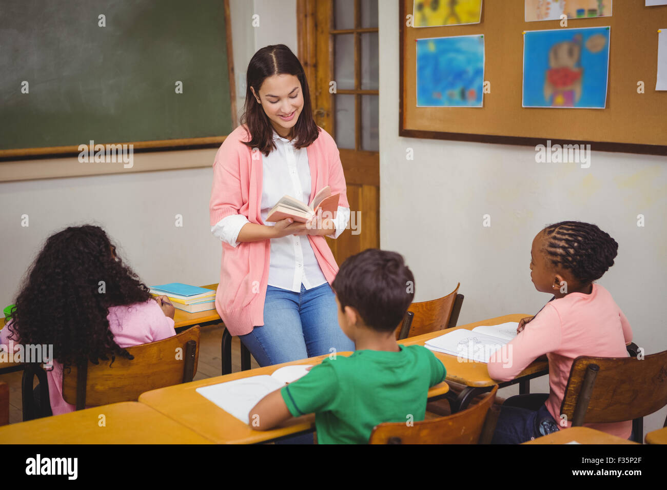 Teacher reading out loud to classroom Stock Photo - Alamy
