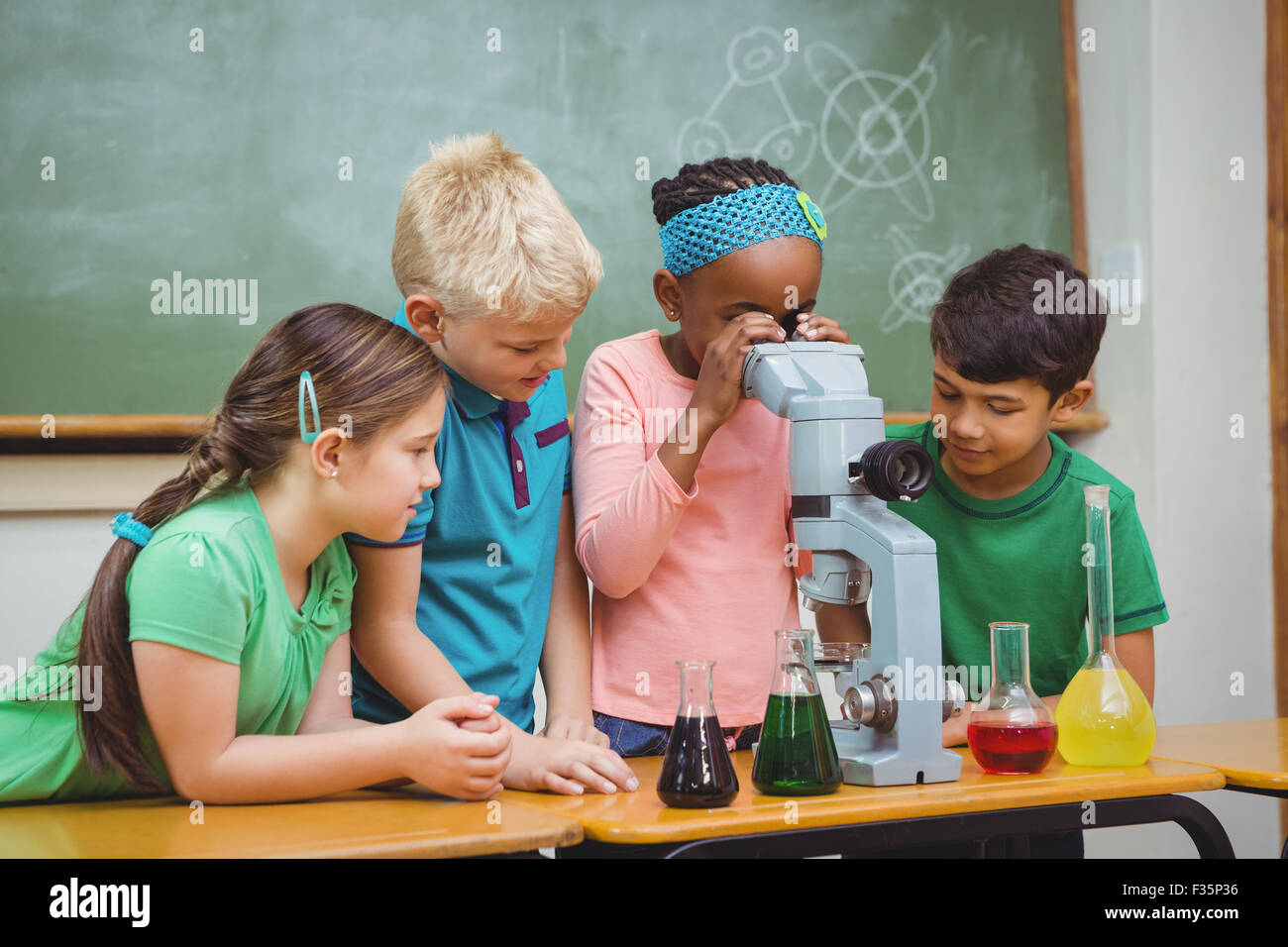 Students using science beakers and a microscope Stock Photo - Alamy