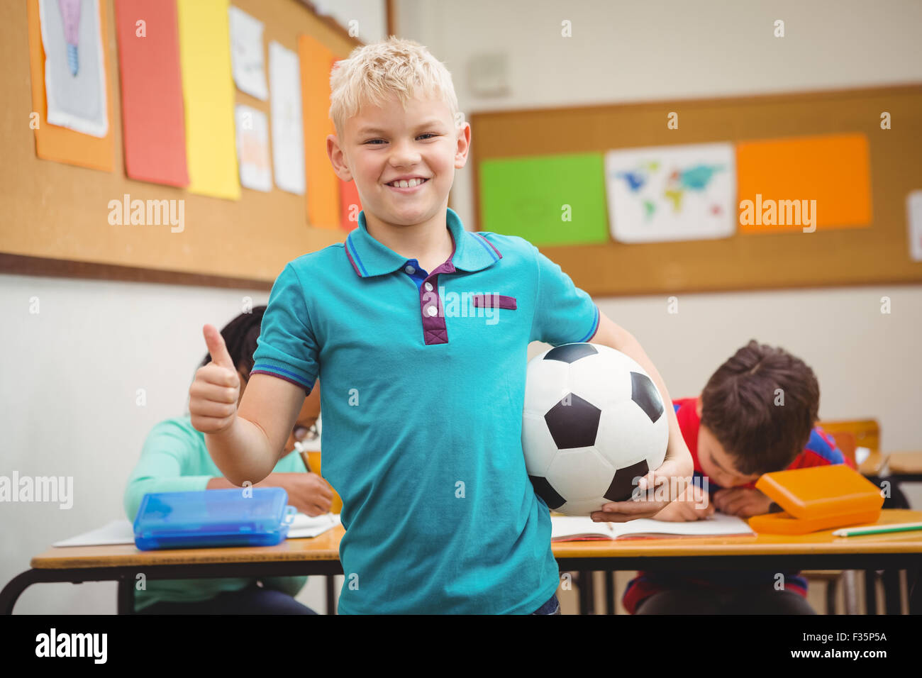 Smiling student holding a football Stock Photo - Alamy