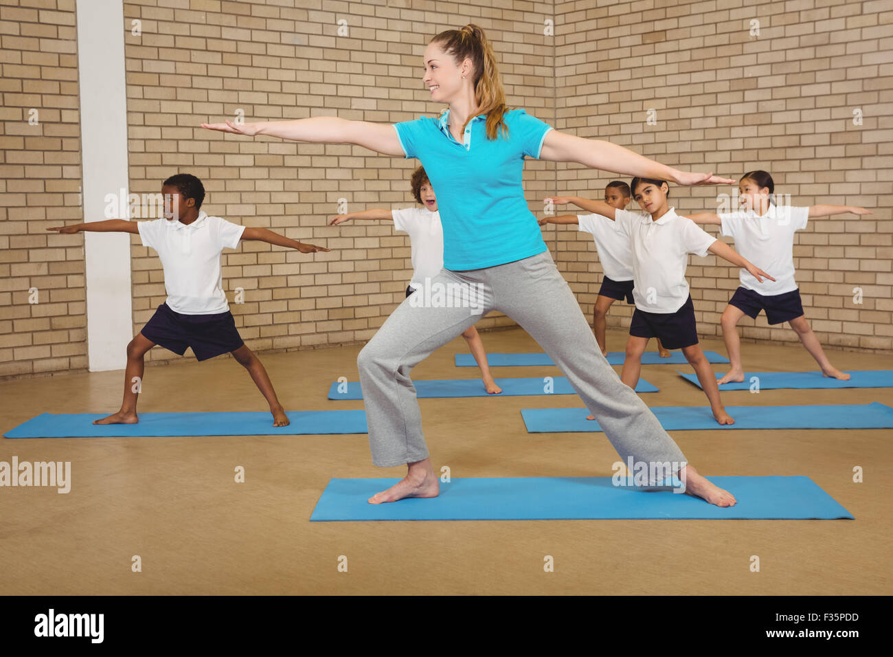 Students and teacher doing yoga pose Stock Photo - Alamy