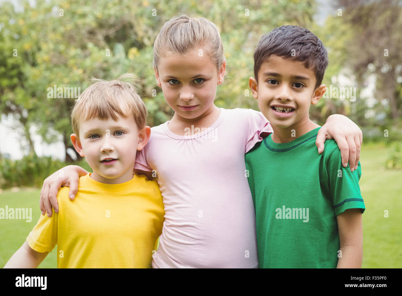 Happy children standing together with arms around each other Stock ...