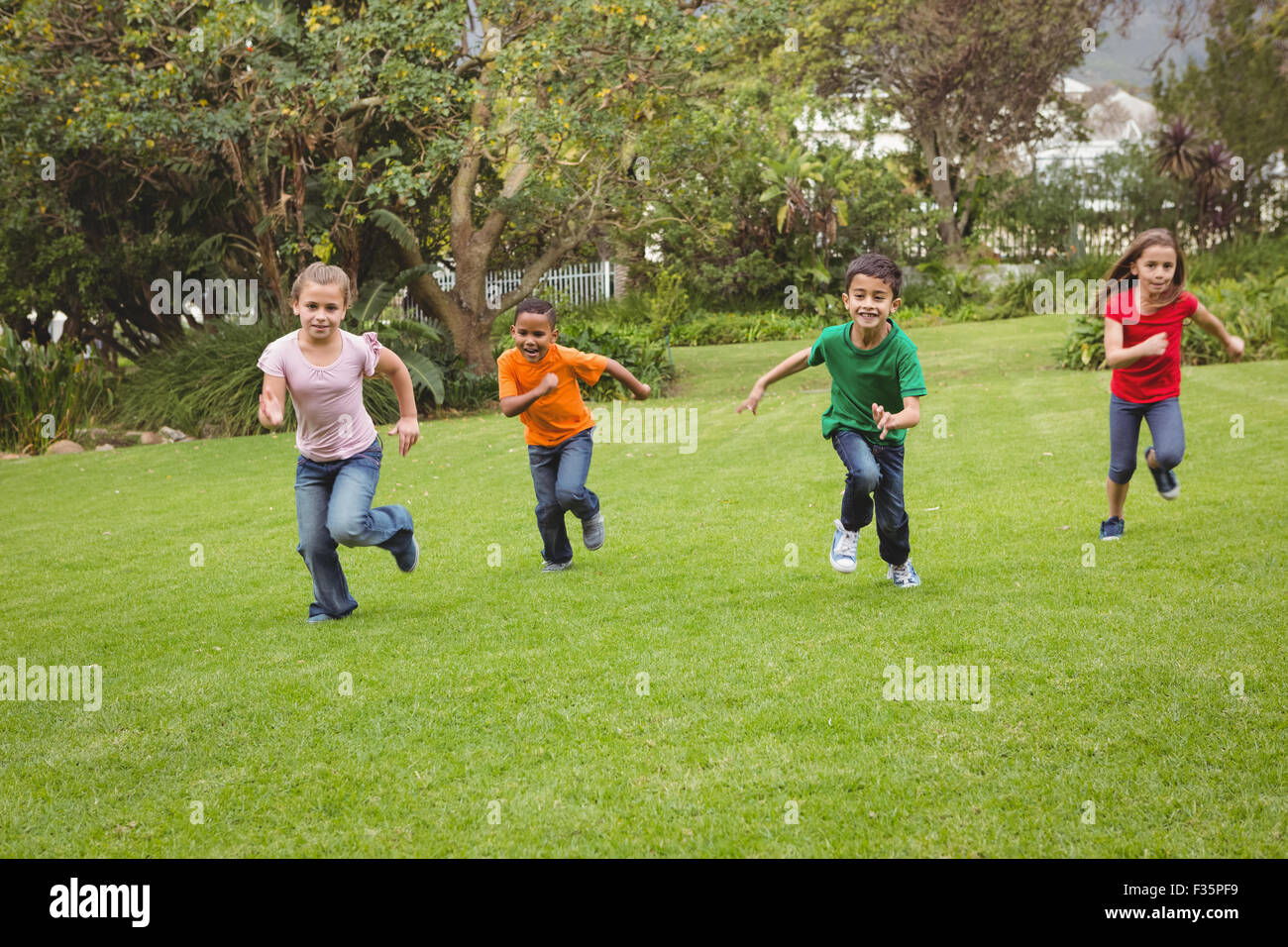 Happy kids running across the grass Stock Photo - Alamy