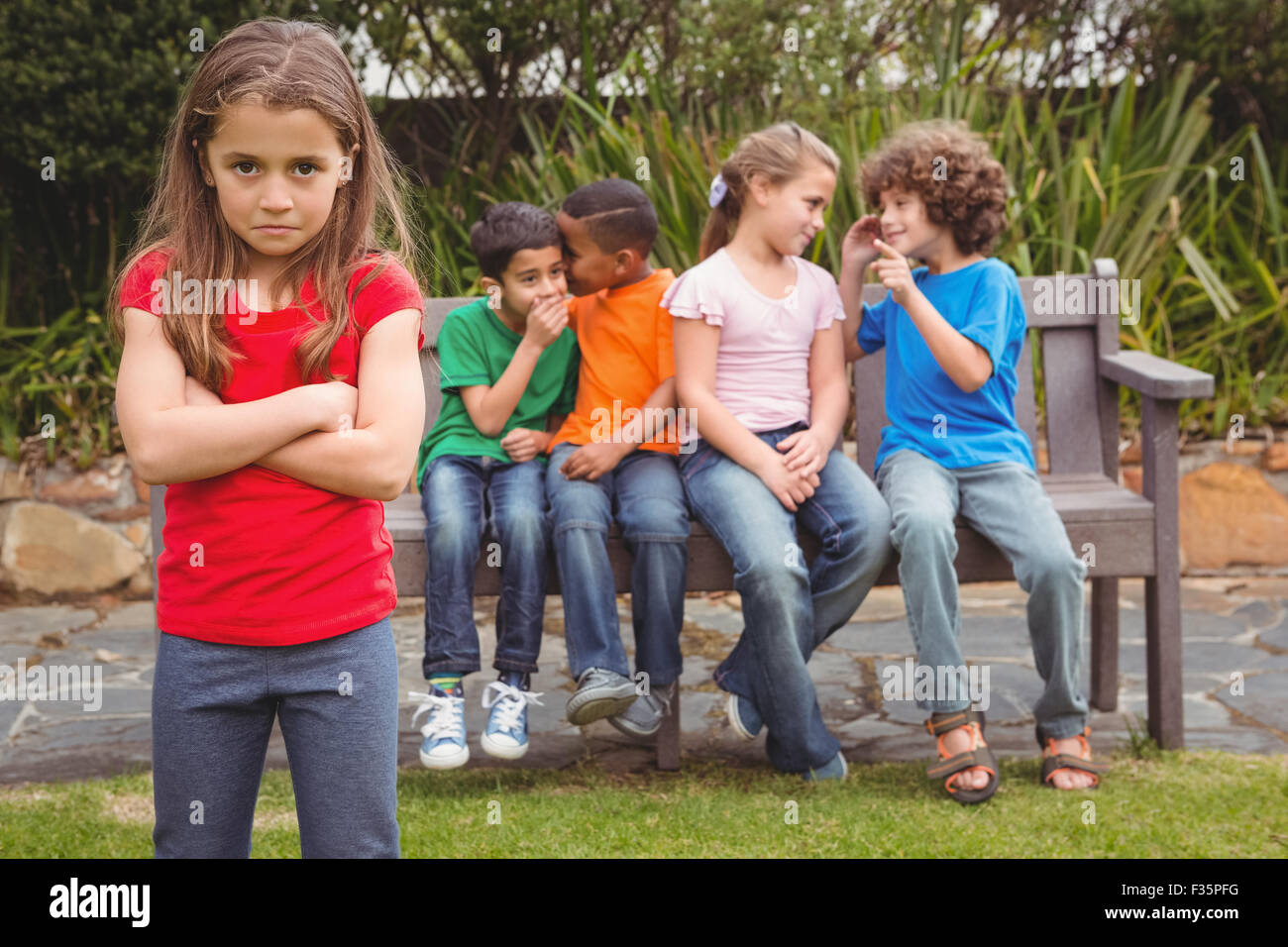 Upset child standing away from group Stock Photo - Alamy