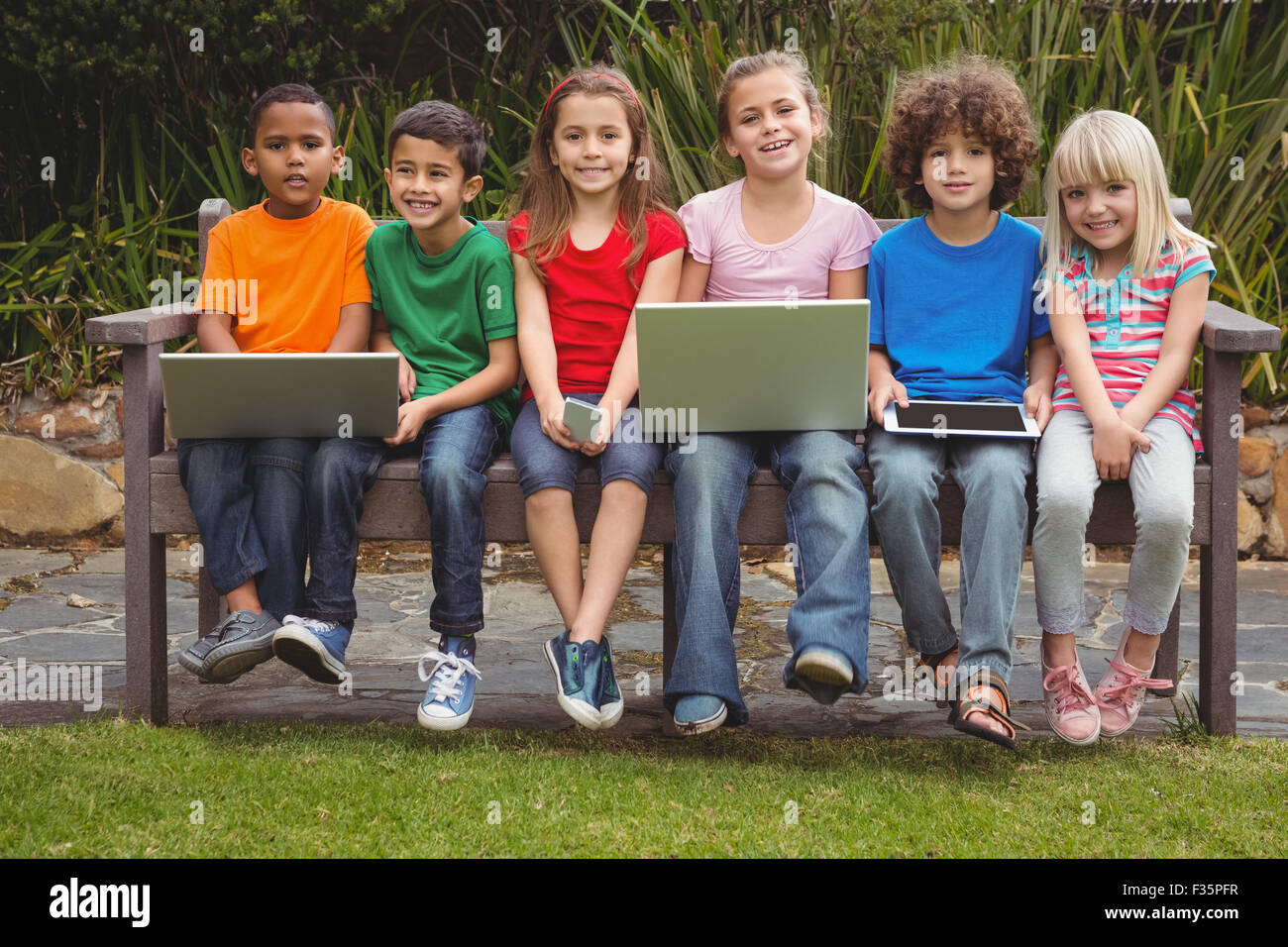 Kids sitting on a park bench Stock Photo - Alamy