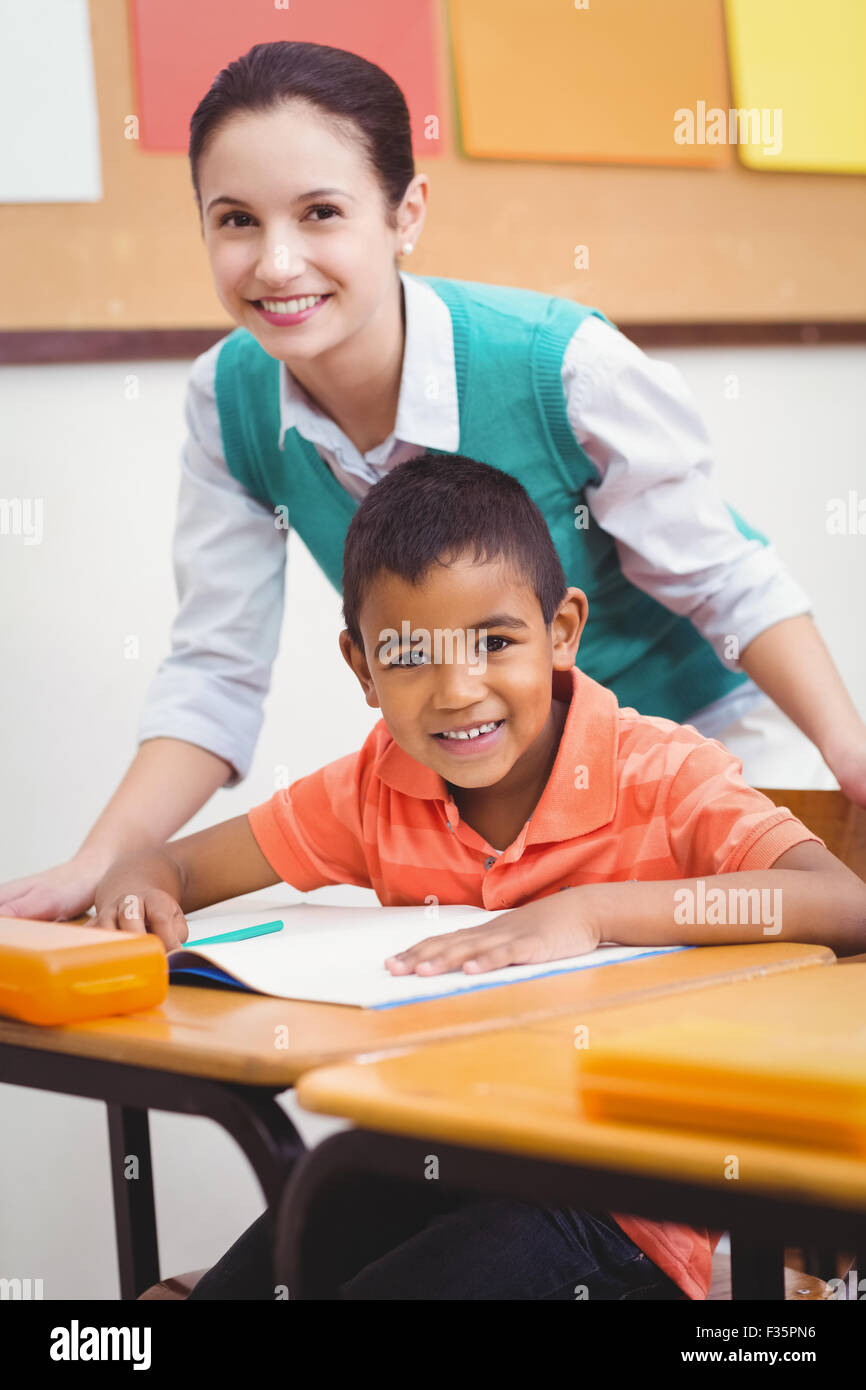 Teacher helping a little boy during class Stock Photo - Alamy