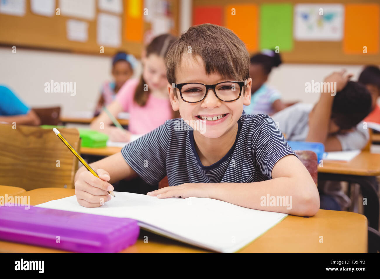 Little boy working at his desk in class Stock Photo - Alamy