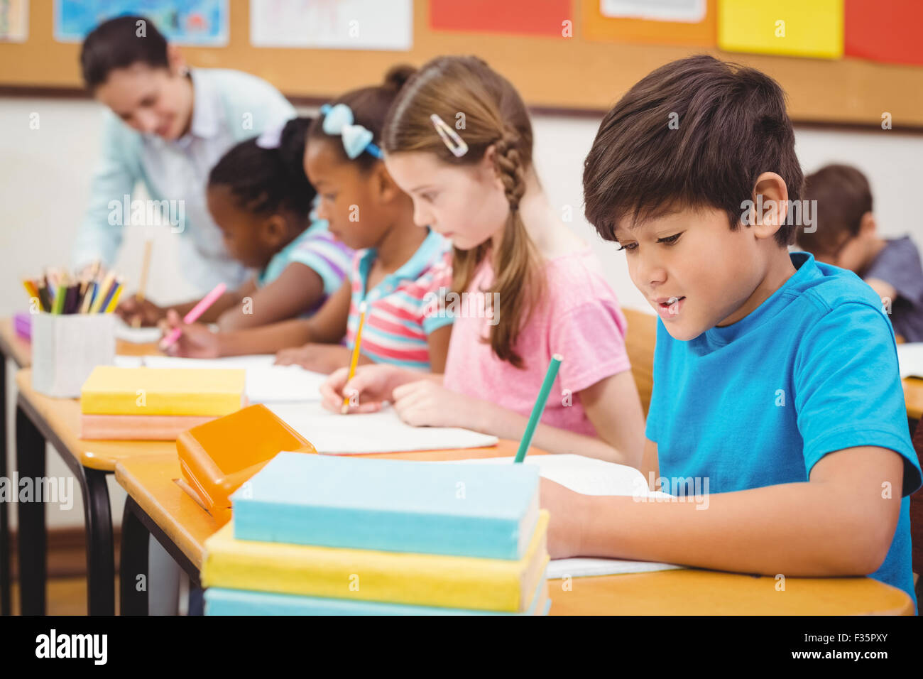 Pupils working at their desks in class Stock Photo - Alamy