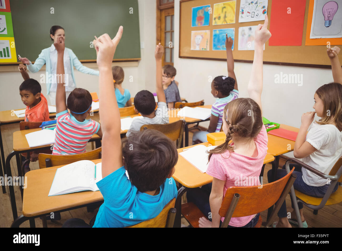 Pupils raising their hands during class Stock Photo - Alamy
