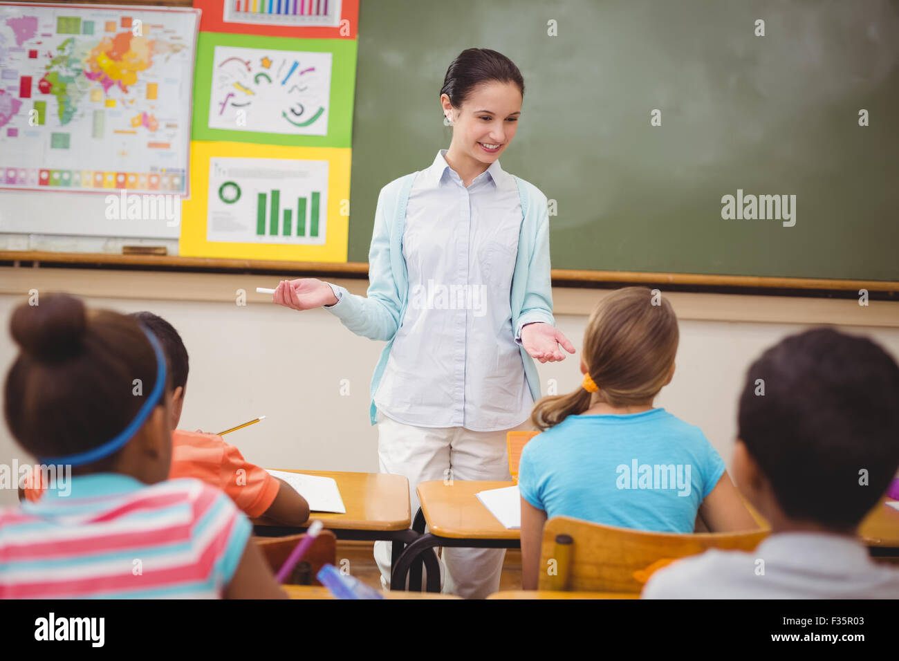Pupils listening to their teacher at chalkboard Stock Photo - Alamy