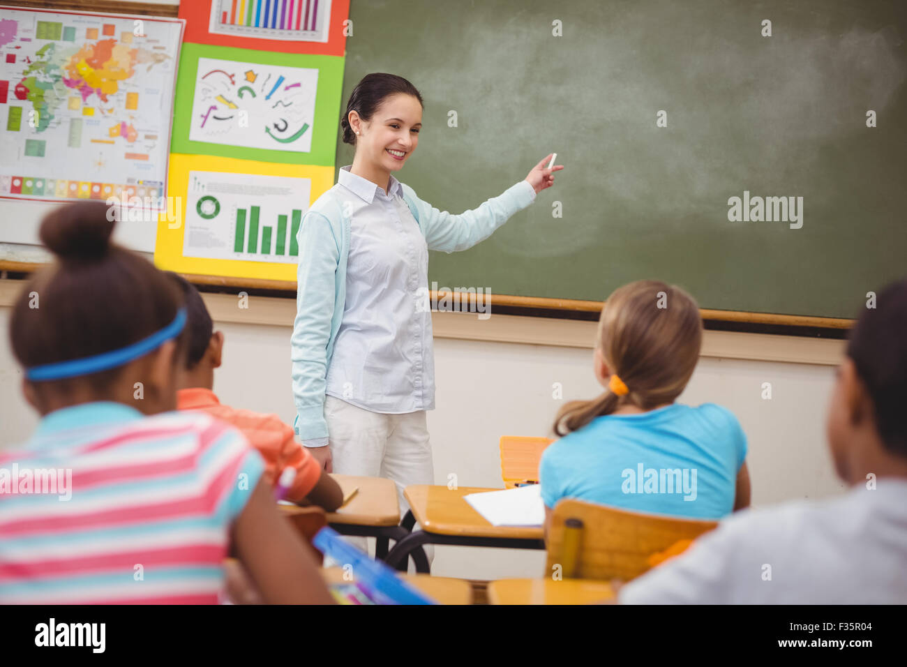 Pupils listening to their teacher at chalkboard Stock Photo - Alamy