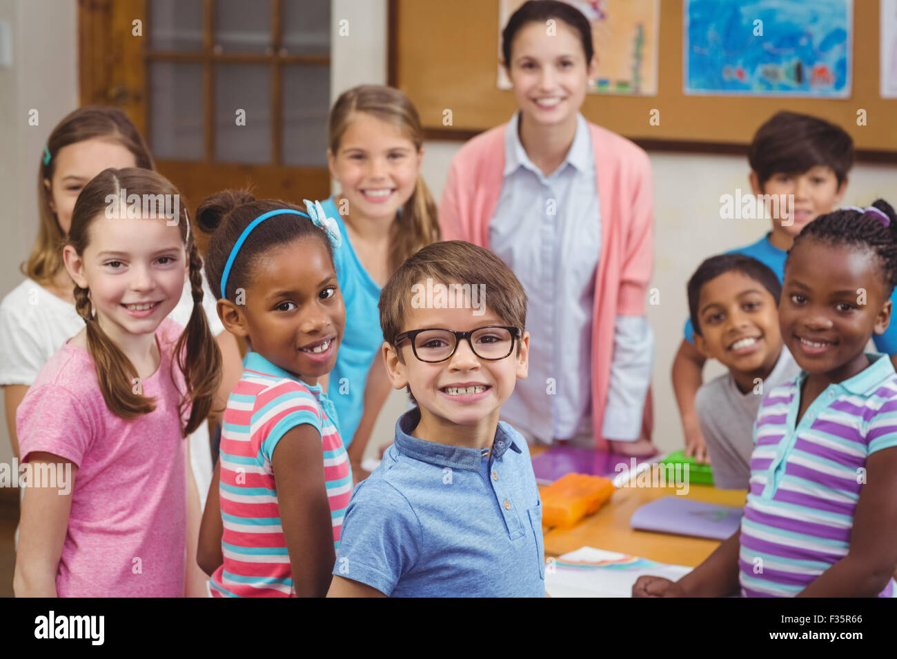 Teacher and pupils working at desk together Stock Photo - Alamy