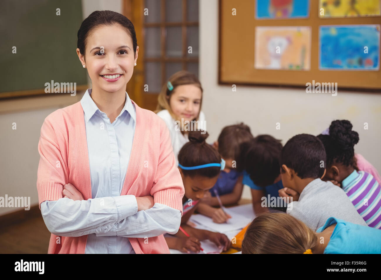 Teacher smiling at camera in classroom Stock Photo - Alamy