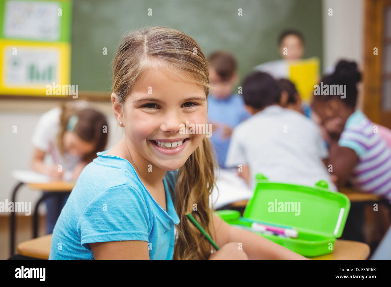 Pupil smiling at camera in classroom Stock Photo - Alamy