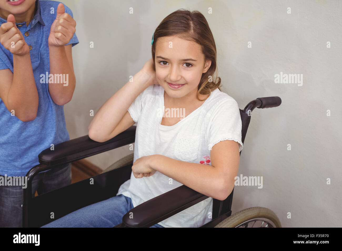 Disabled pupil smiling at camera with classmates Stock Photo - Alamy
