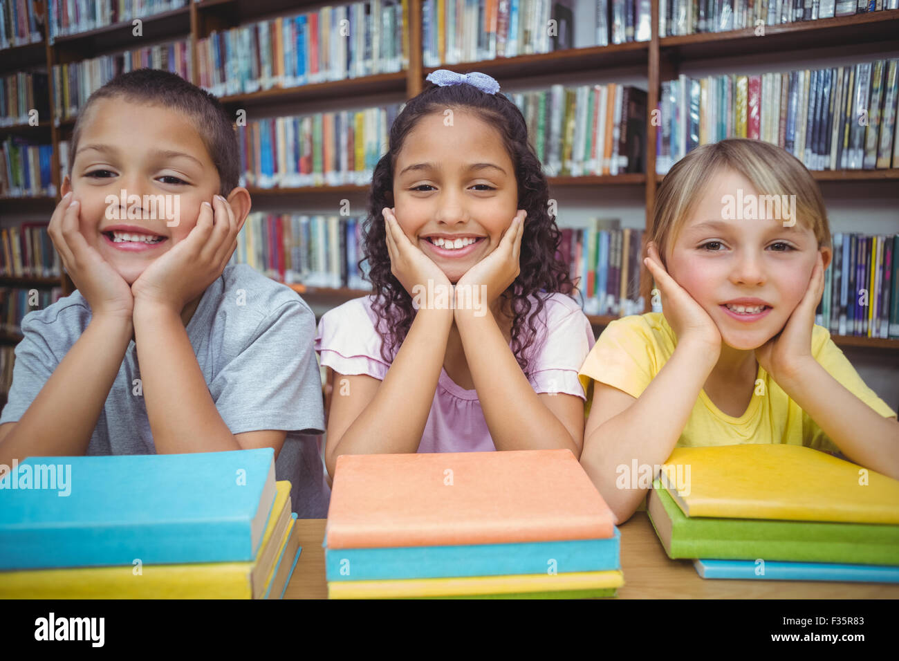 Pupils smiling camera in library hi-res stock photography and images ...