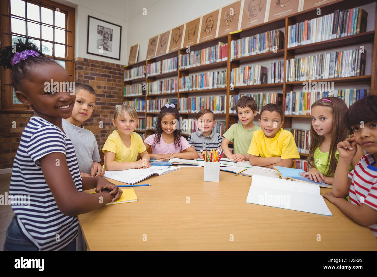 Pupils working together at desk in library Stock Photo - Alamy