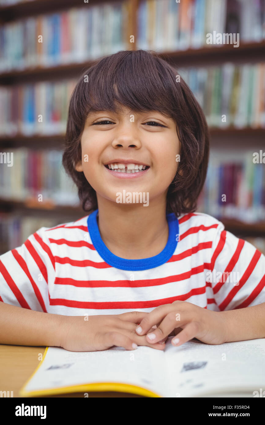 Pupil reading book at desk in library Stock Photo - Alamy