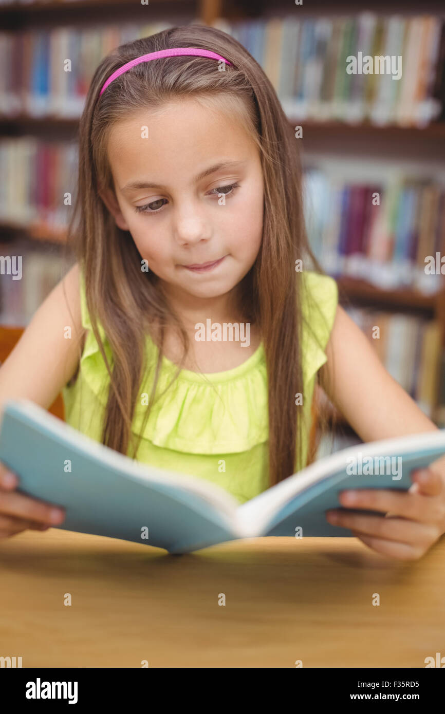 Pupil reading book at desk in library Stock Photo - Alamy
