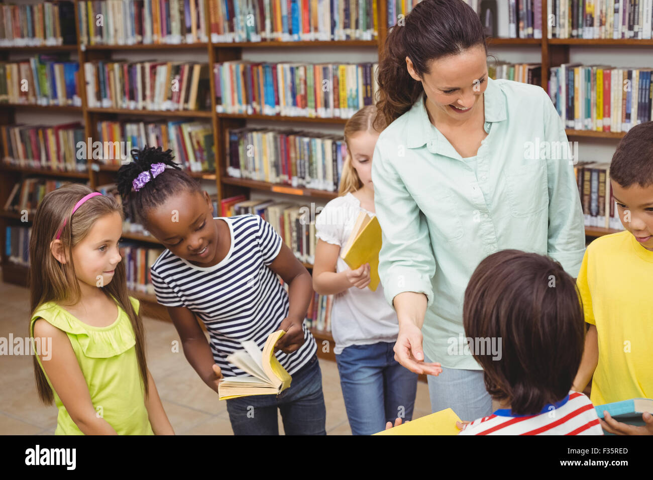 Pupils and teacher in the library Stock Photo - Alamy