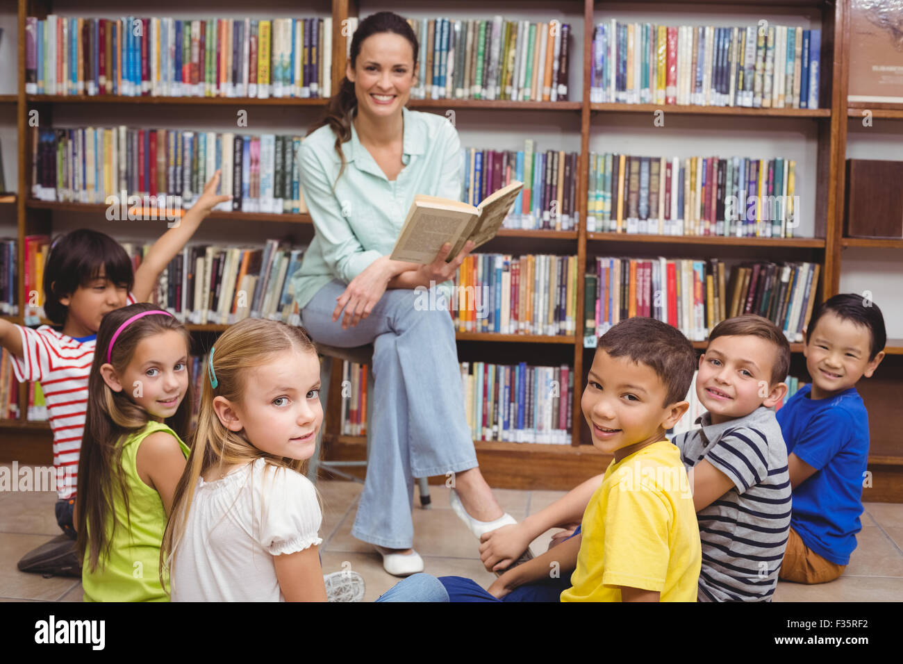 Teacher reading her pupils a story Stock Photo - Alamy