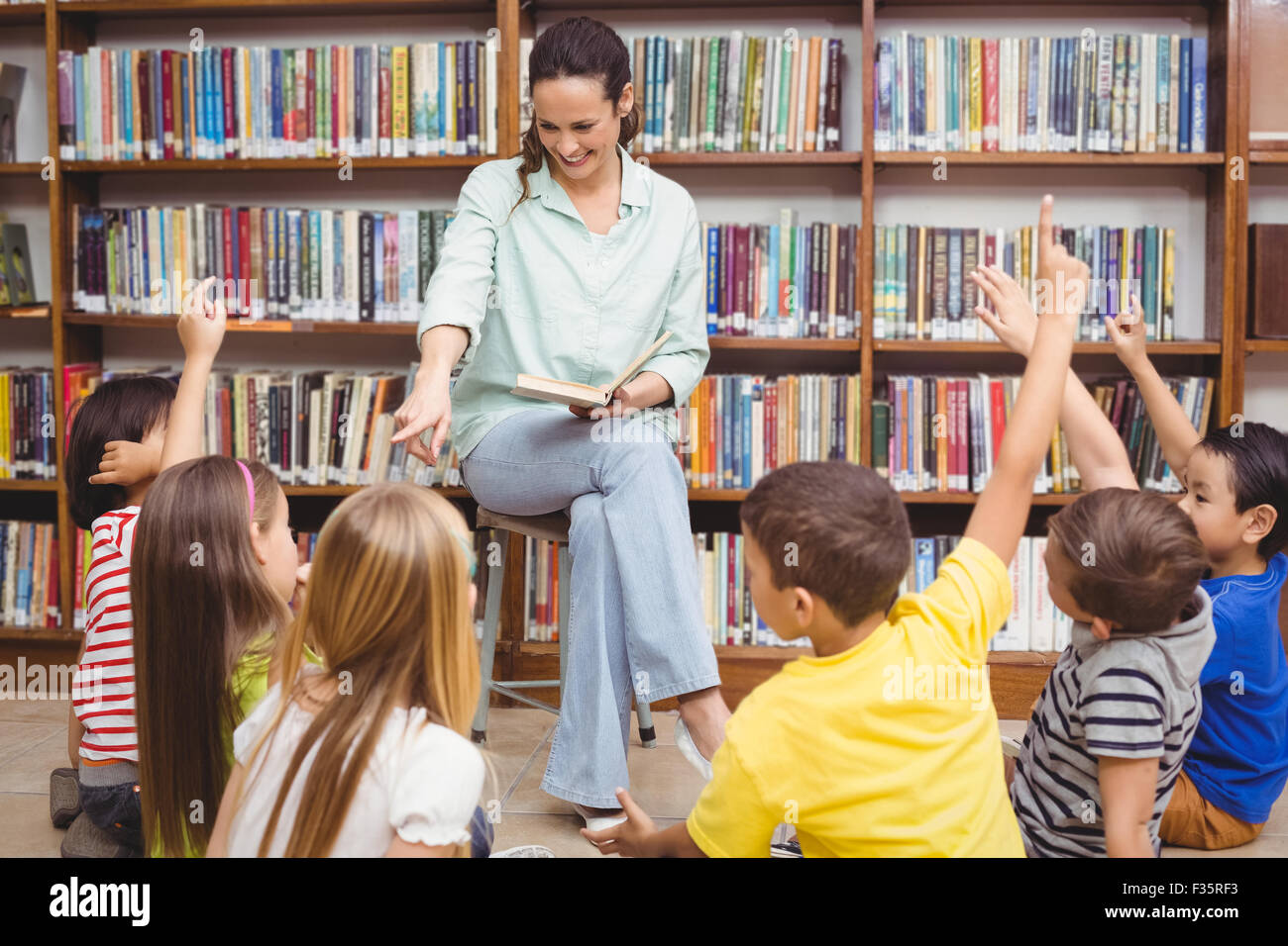 Teacher reading her pupils a story Stock Photo - Alamy