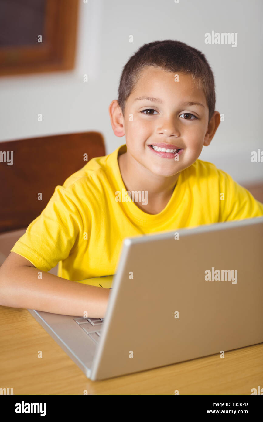 Cute pupil in class using laptop Stock Photo - Alamy