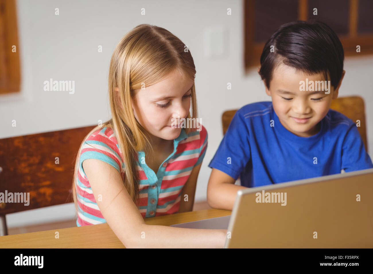 Cute pupils in class using laptop Stock Photo - Alamy