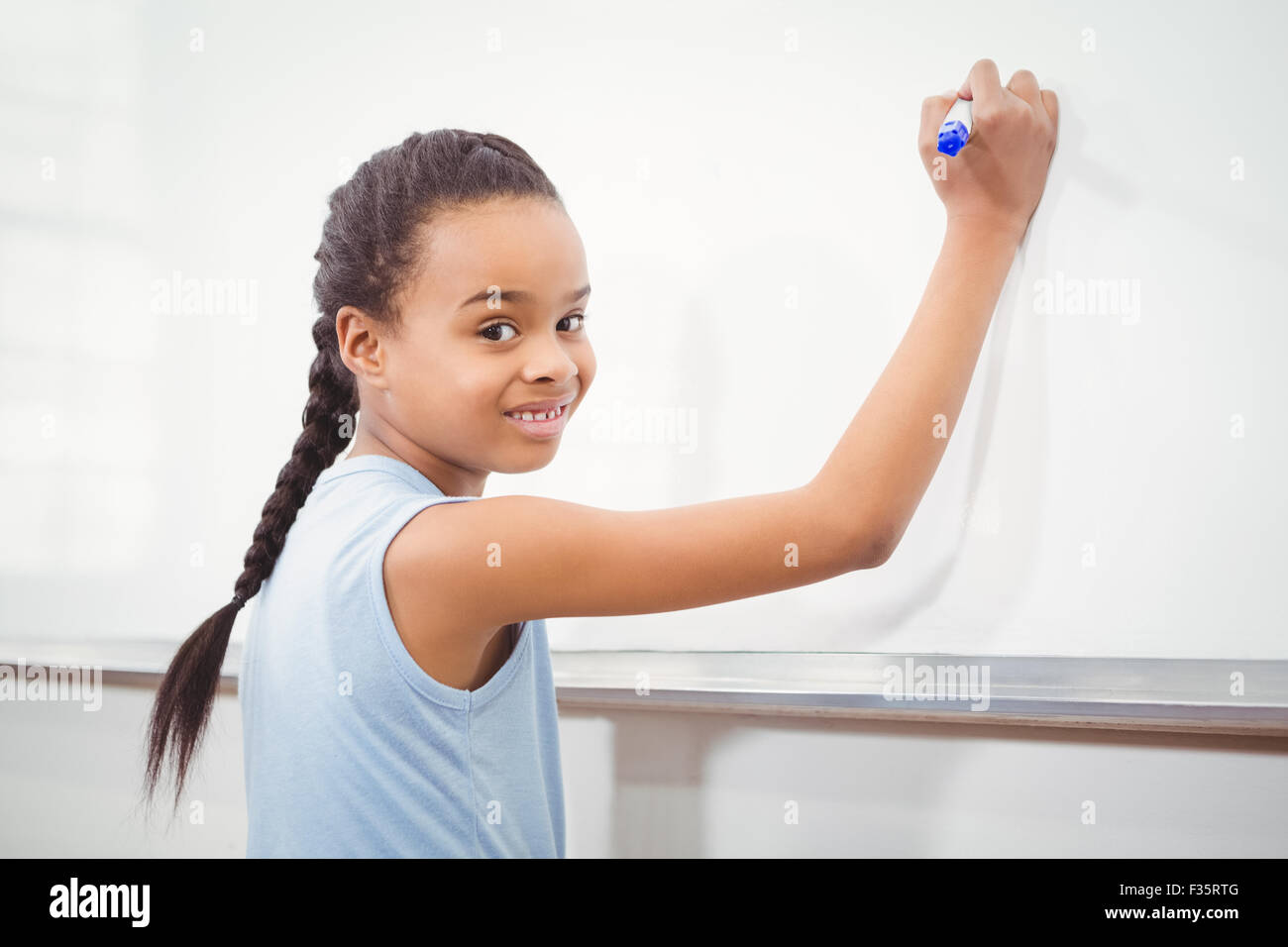 Smiling student writing on whiteboard Stock Photo - Alamy