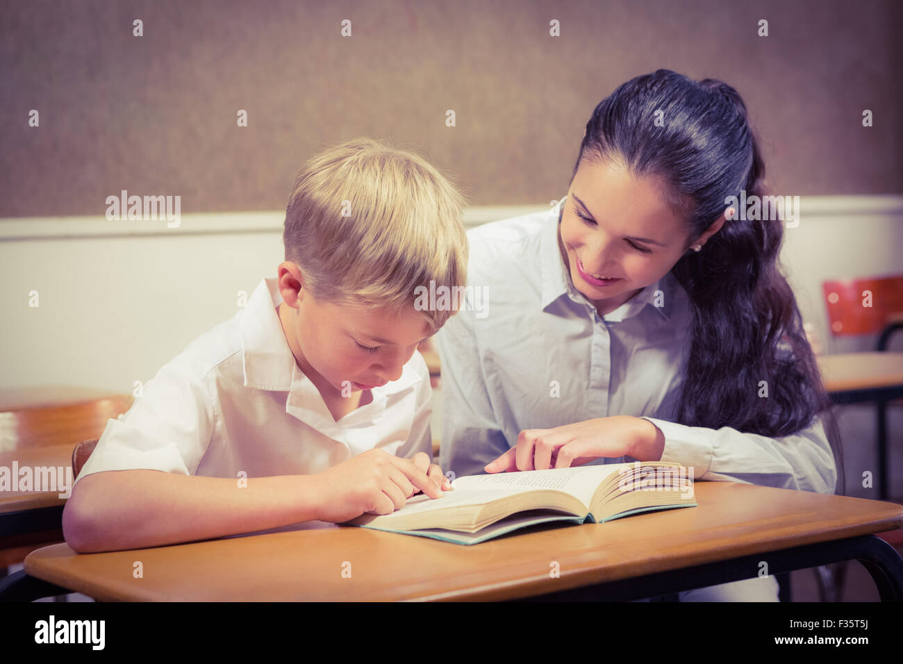 Teacher helping a student in class Stock Photo - Alamy