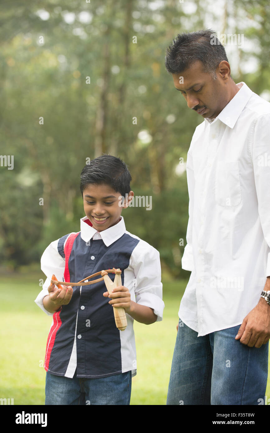 indian father and son playing slingshot at the park Stock Photo - Alamy
