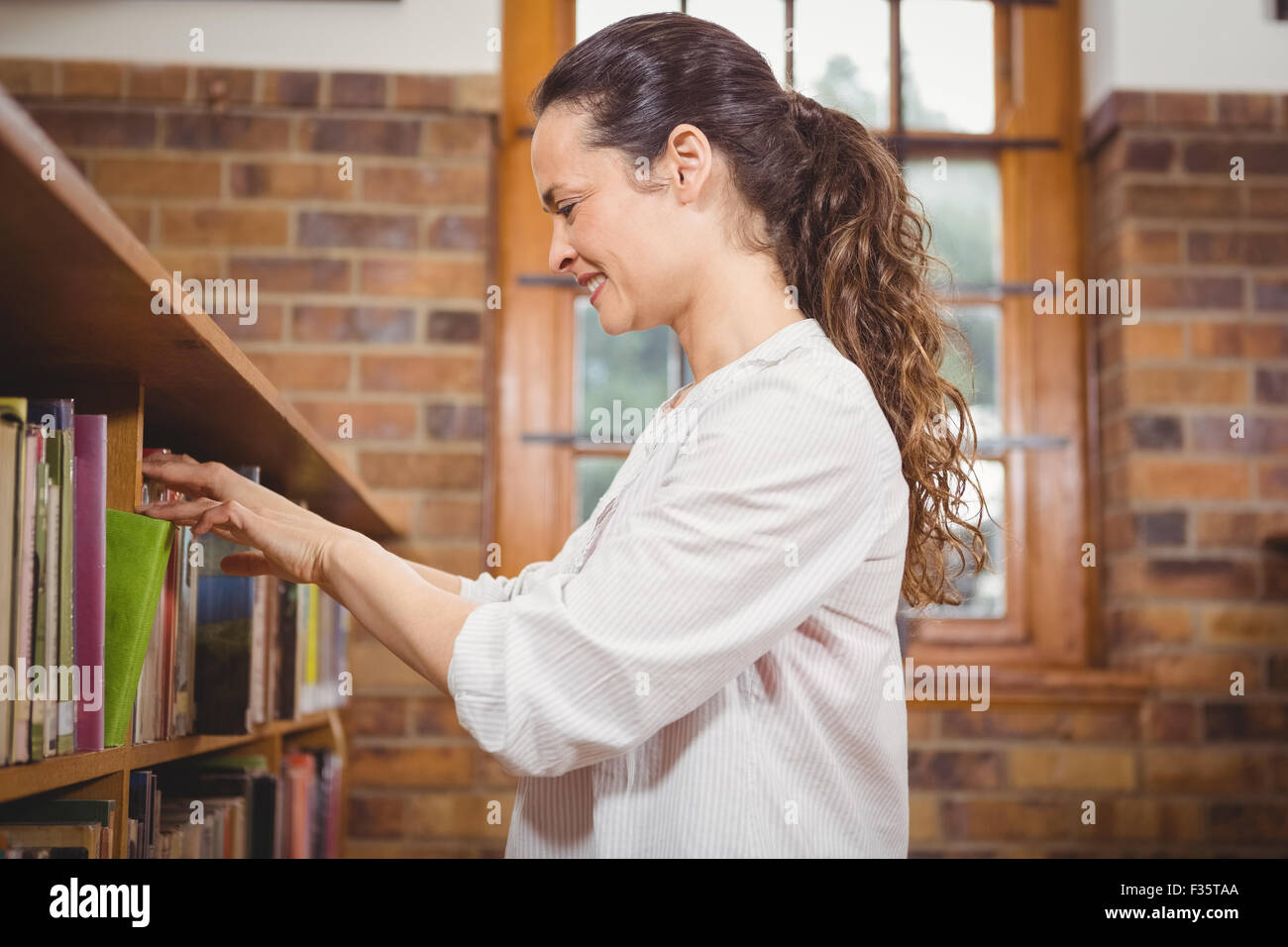 Librarian sorting books on the shelves Stock Photo - Alamy