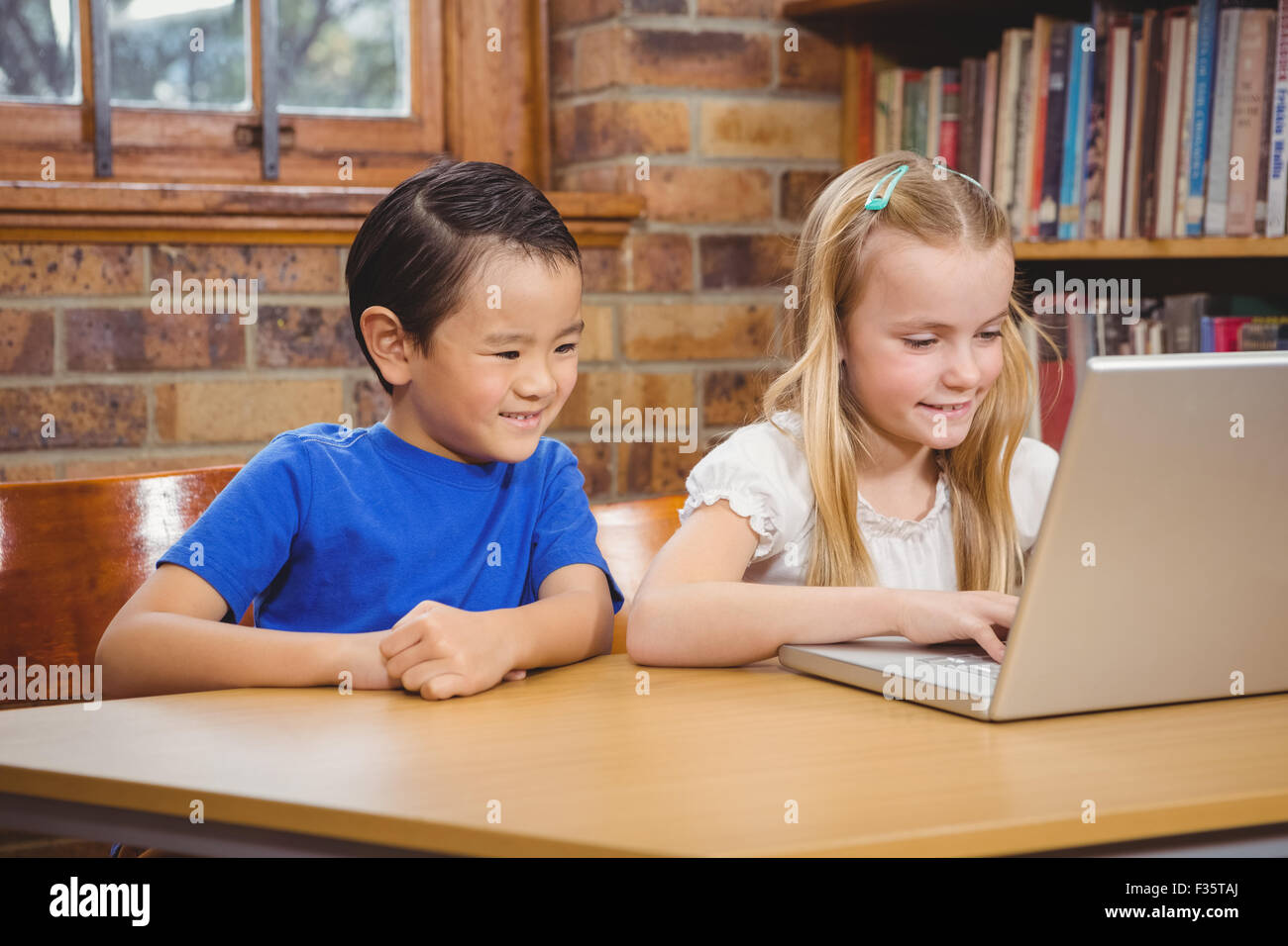 Smiling elementary students laptop hi-res stock photography and images ...