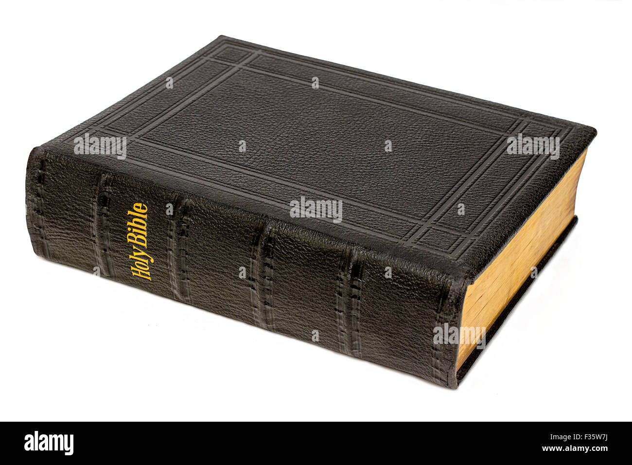 Large antique holy bible, black leather with gold writing, with a white ...