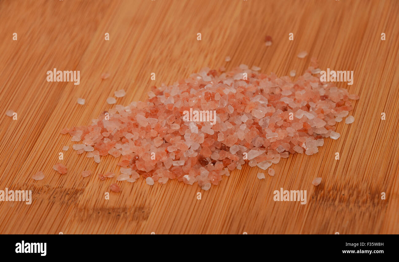 Himalayan pink salt batch over wooden bamboo background, angle view ...
