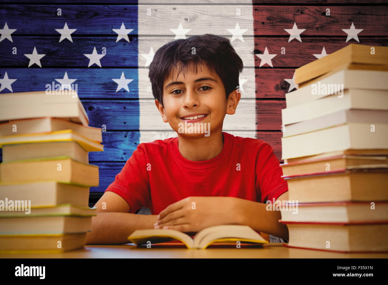 Composite image of portrait of boy reading book at desk Stock Photo - Alamy