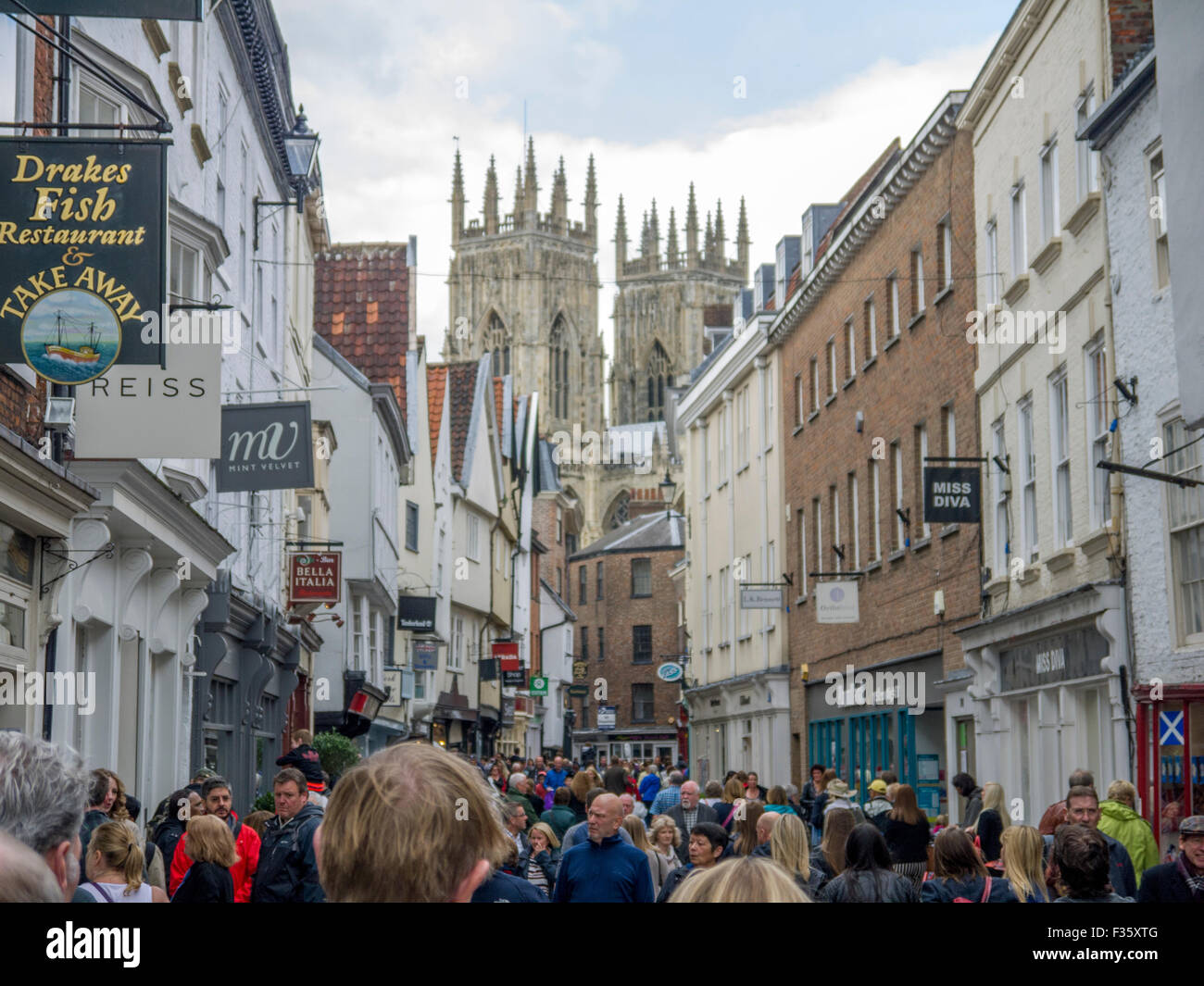 Old shopping street full of people in York, with York Minster in the ...