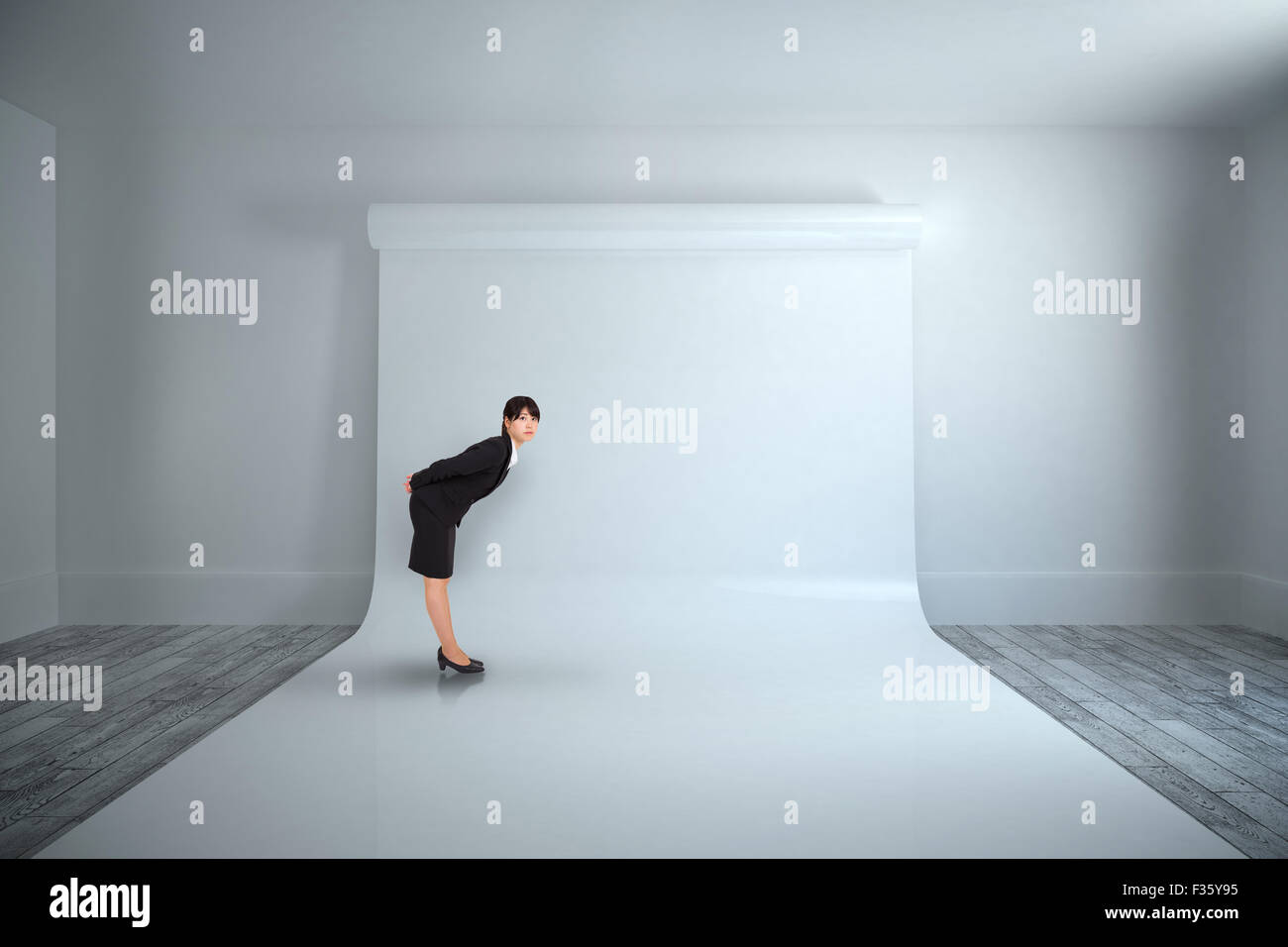Composite image of serious businesswoman bending bending against white ...