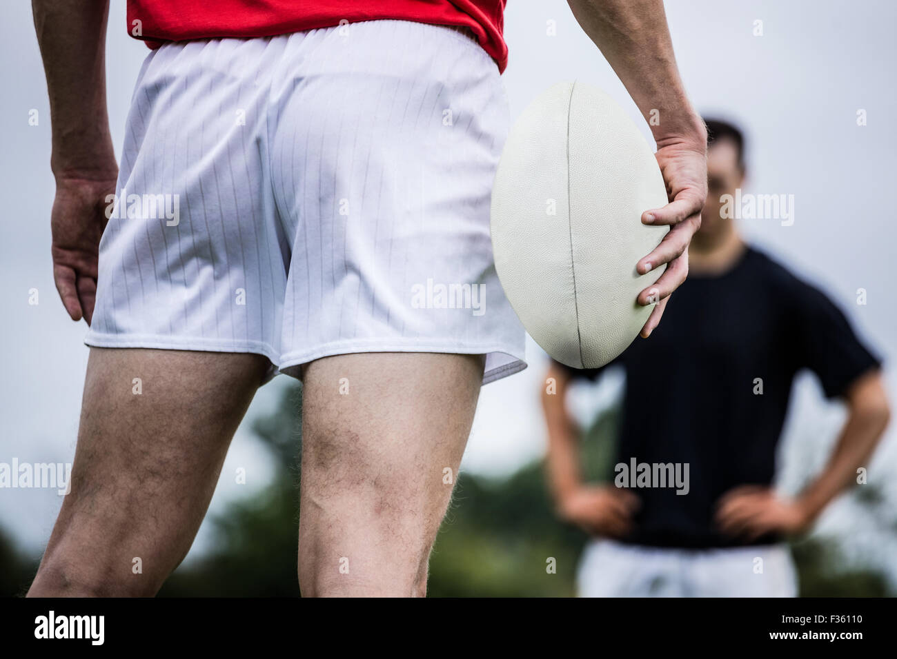 Rugby player standing with ball Stock Photo - Alamy
