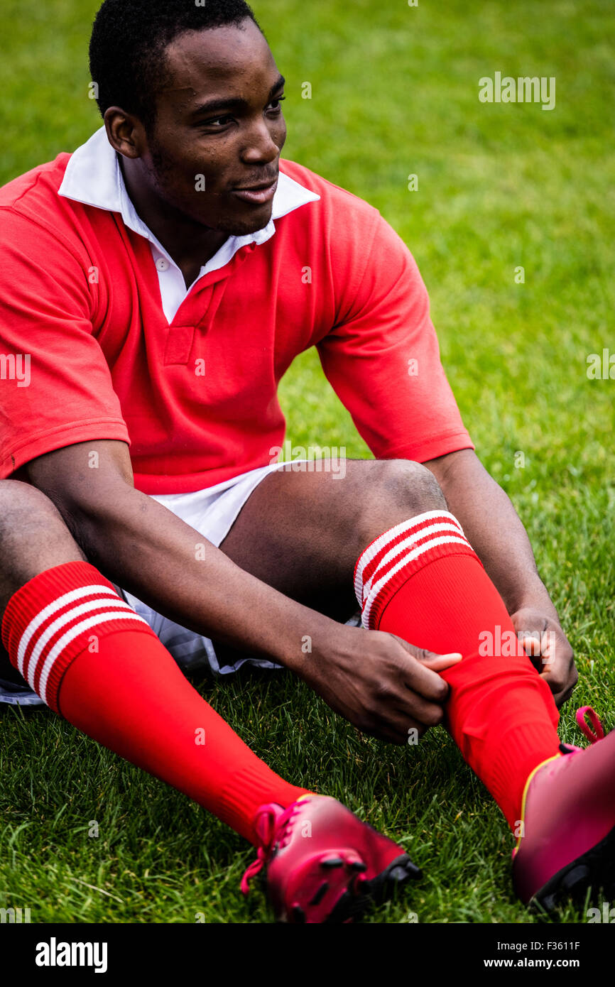 Rugby player sitting on grass Stock Photo - Alamy