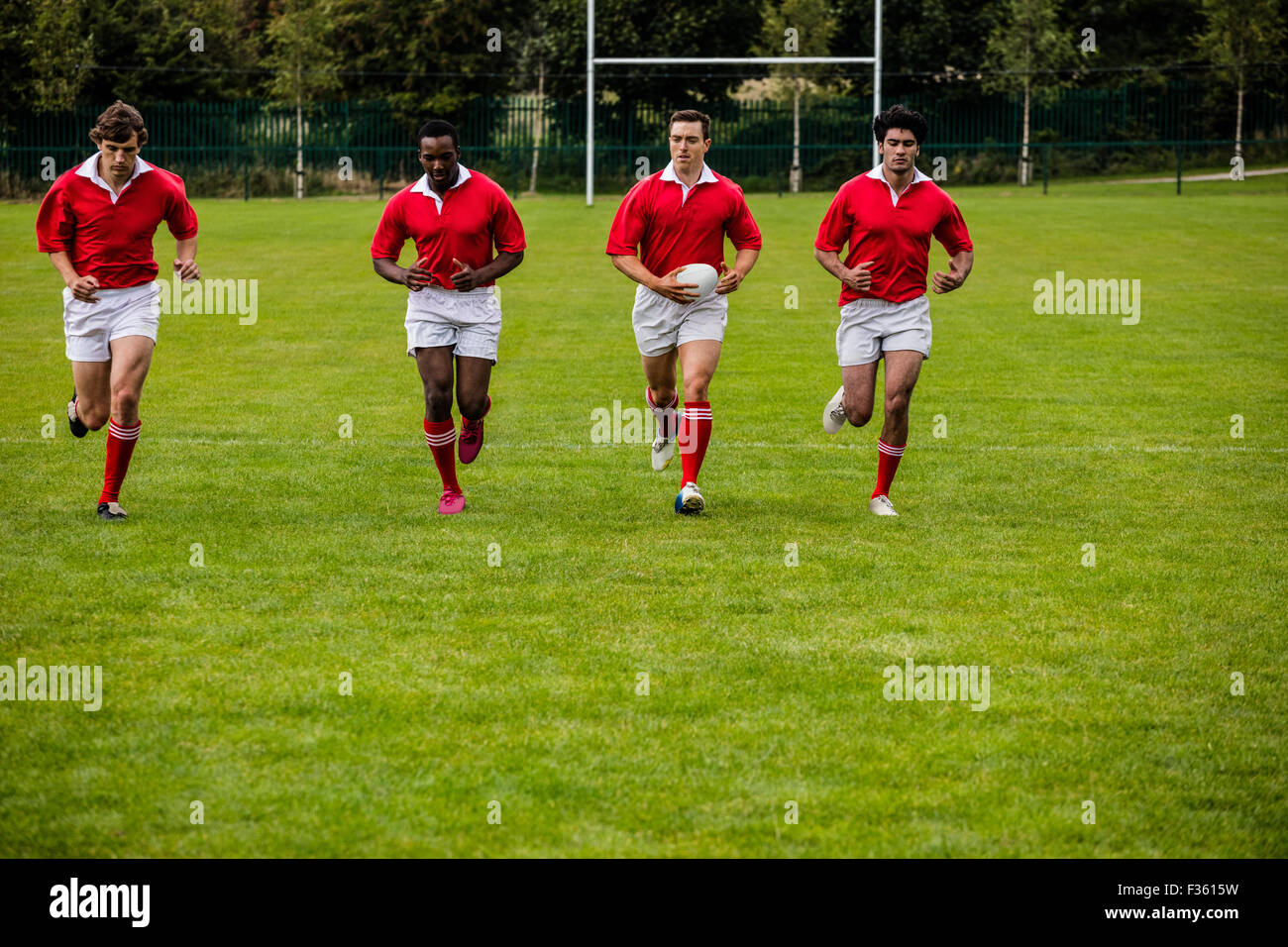 Rugby players jogging with ball Stock Photo - Alamy