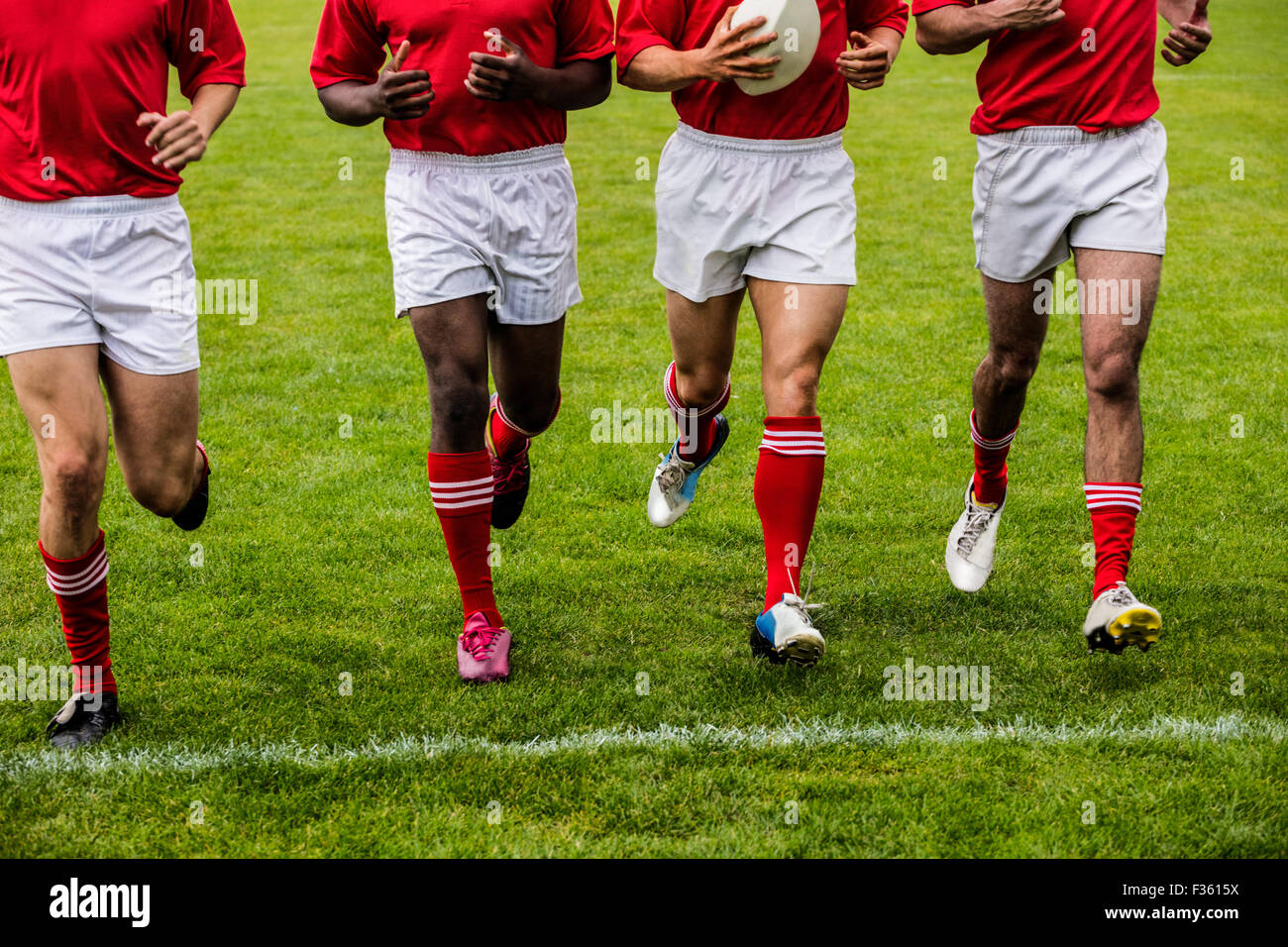 Rugby players jogging with ball Stock Photo - Alamy