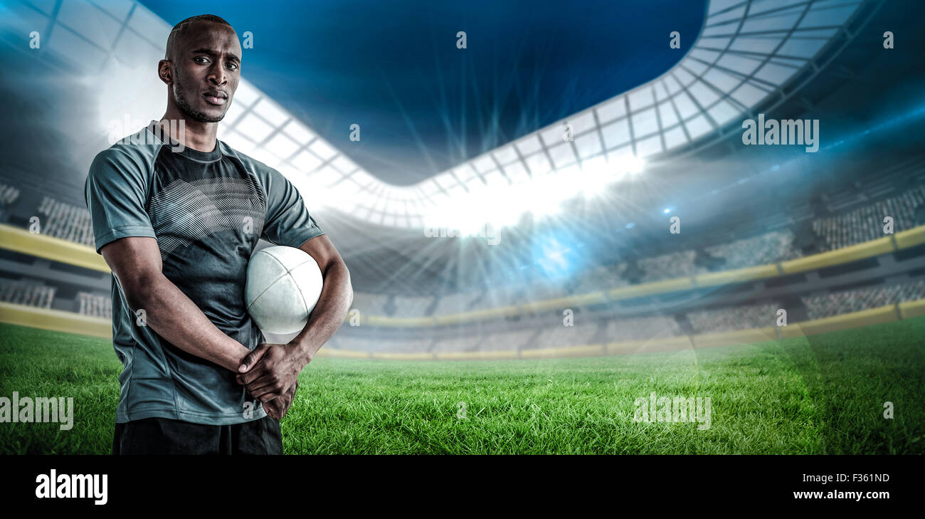 Composite image of portrait of confident sportsman with rugby ball ...