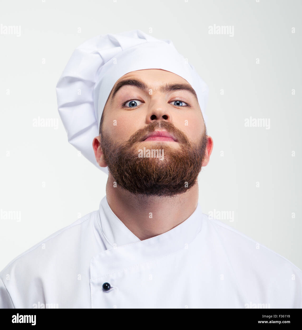 Portrait of a serious male chef cook looking at camera isolated on a ...